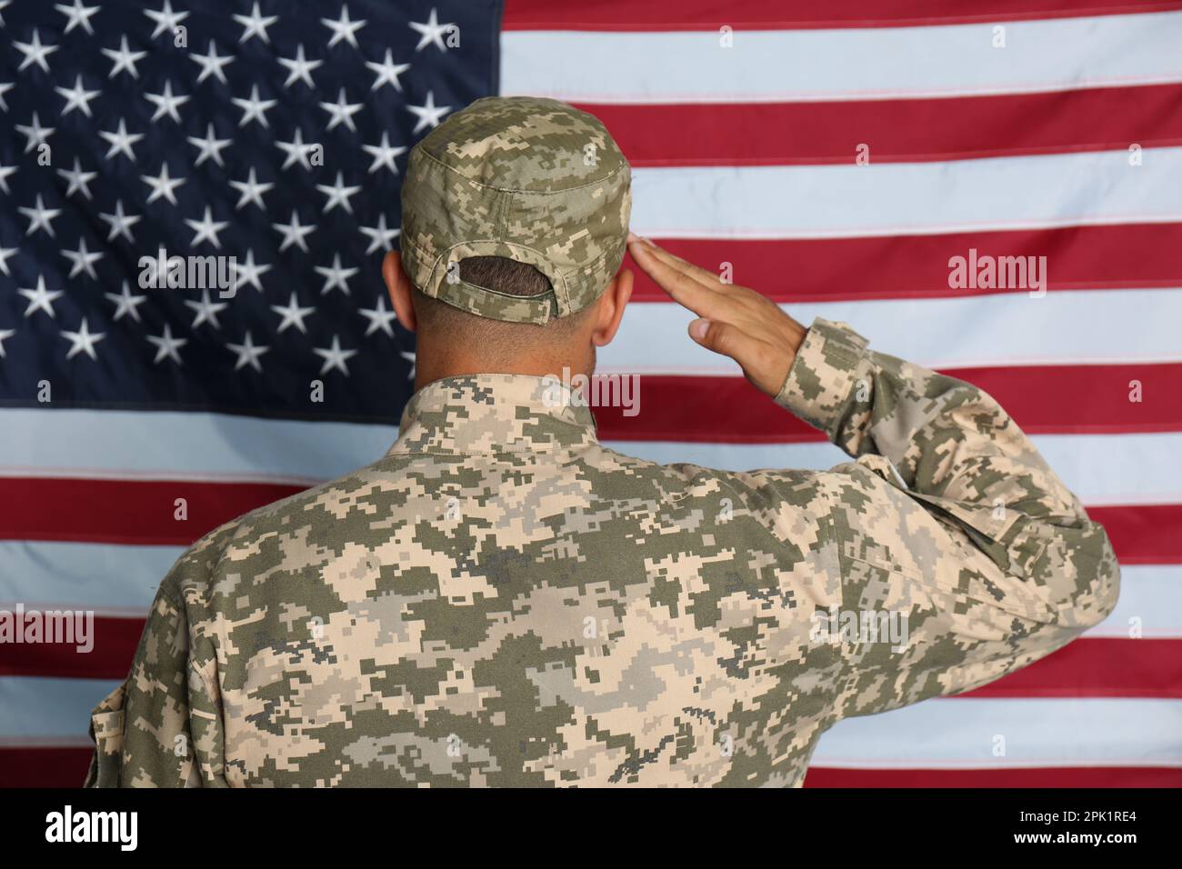 Soldier in uniform against United states of America flag, back view ...