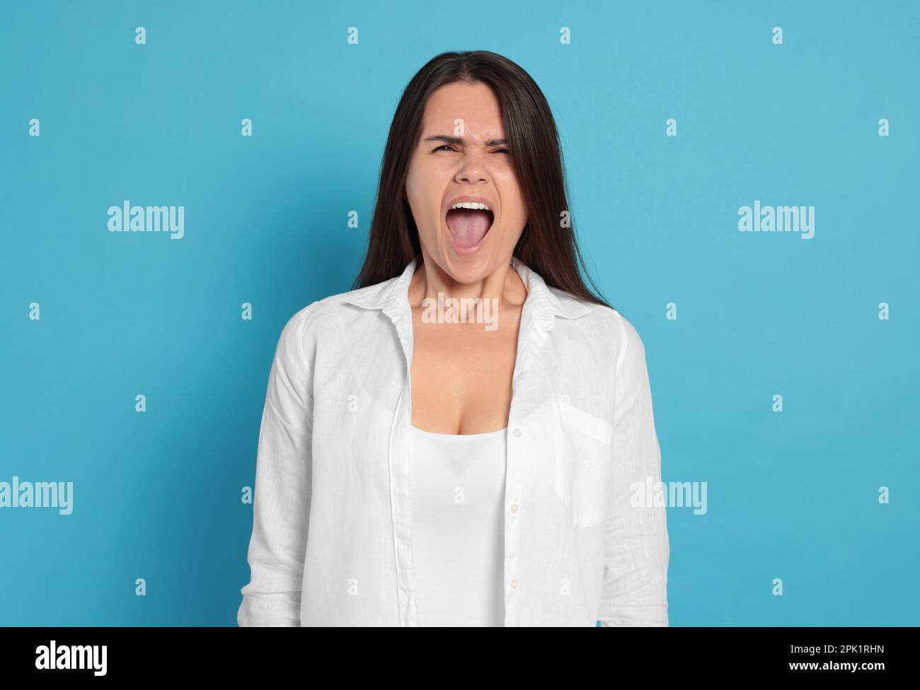 Aggressive young woman shouting on turquoise background Stock Photo - Alamy