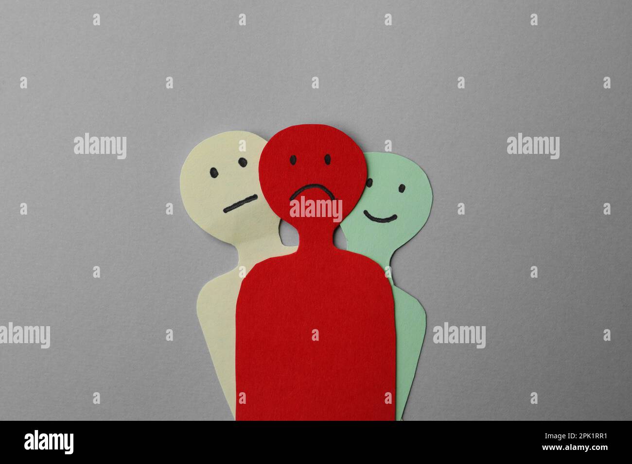 Colorful paper cutouts of person with different emotions on grey ...