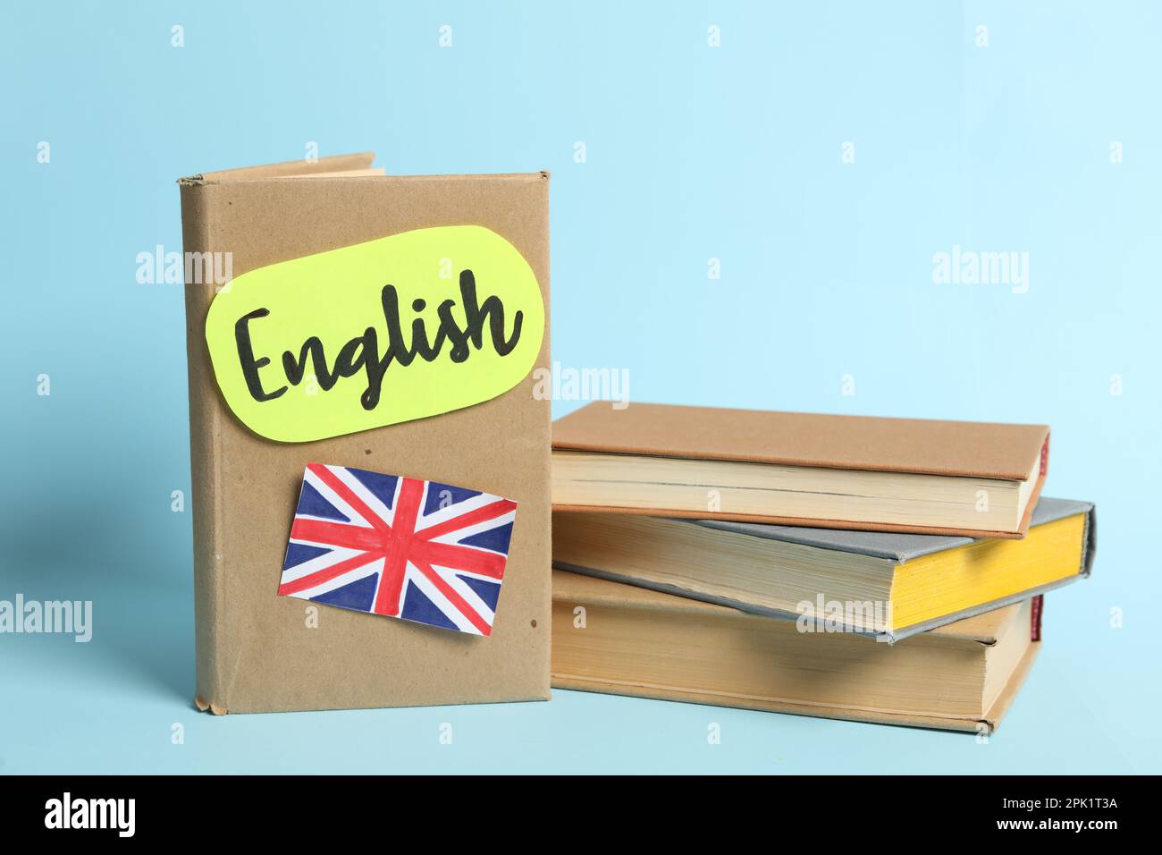 Word English and stack of books on light blue background Stock Photo - Alamy