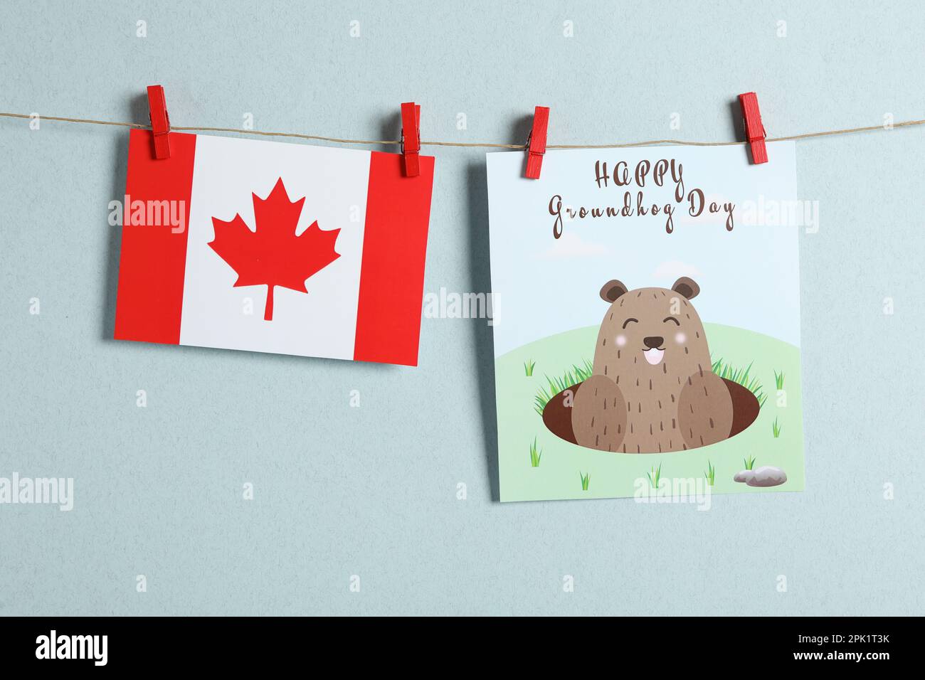 Happy Groundhog Day greeting card and Canada flag hanging against light ...