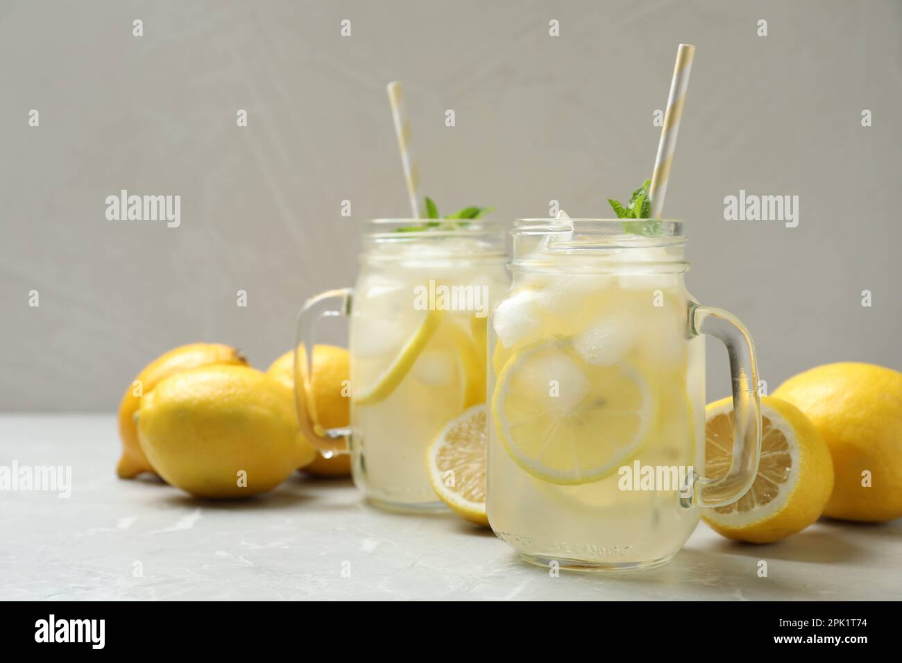 Natural lemonade with mint and fresh fruits on light grey marble table ...