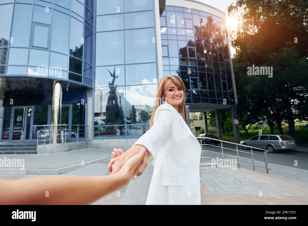 Holding other's person hand. Woman in formal wear standing outdoors in ...