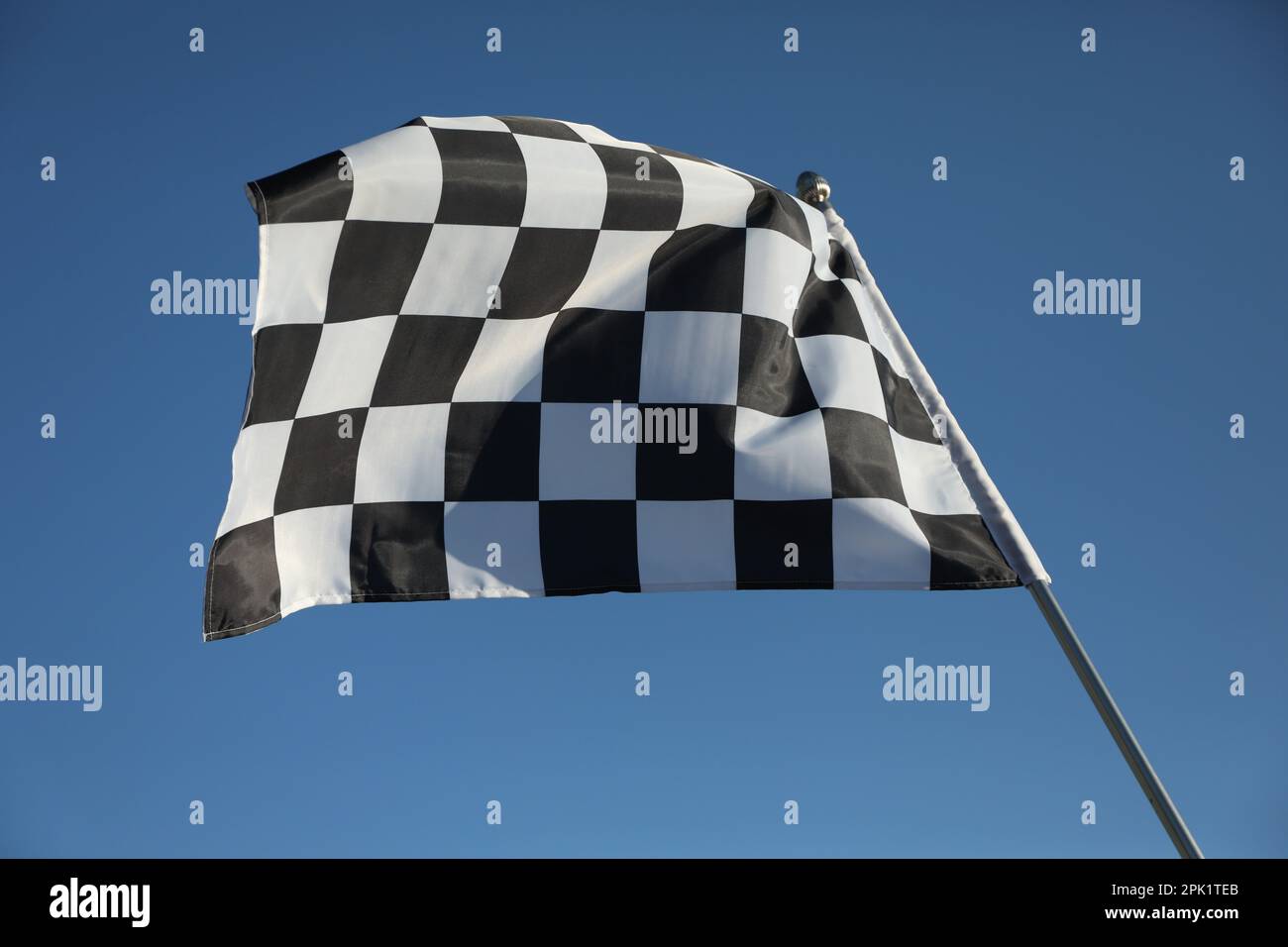 Checkered finish flag on light blue background Stock Photo - Alamy