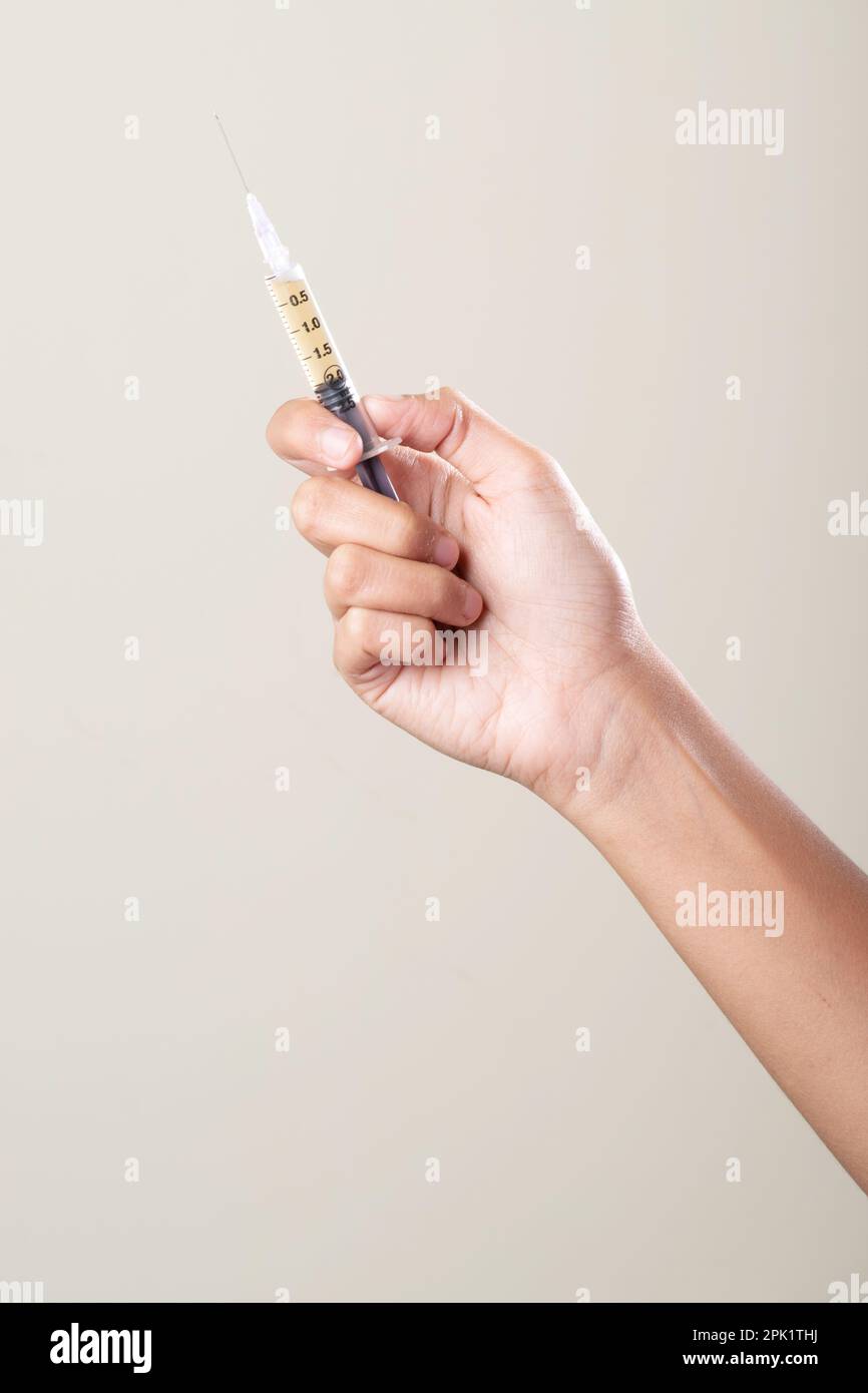 Injection in hand on grey background Stock Photo - Alamy
