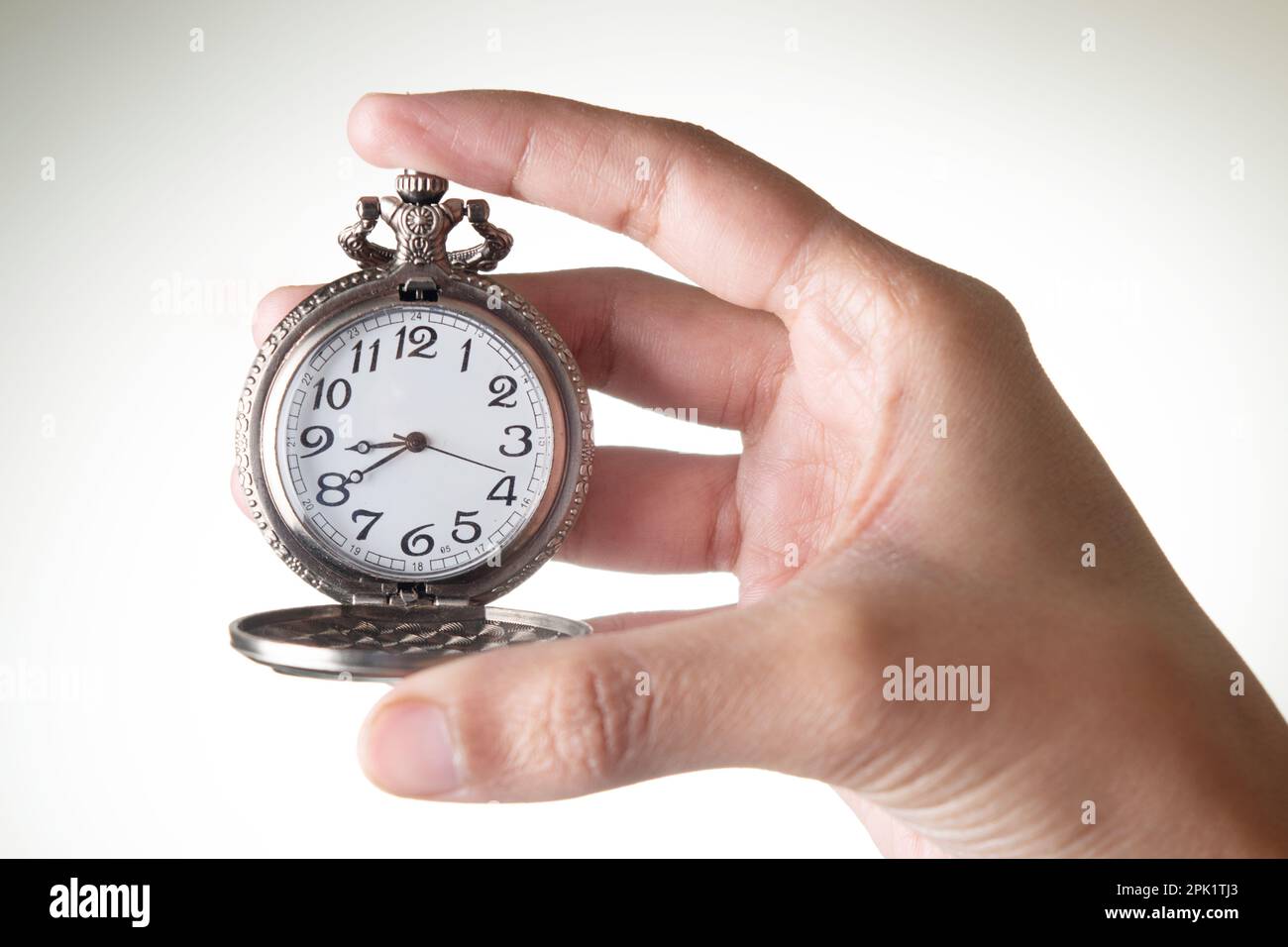 Pocket watch in hand on grey background Stock Photo - Alamy