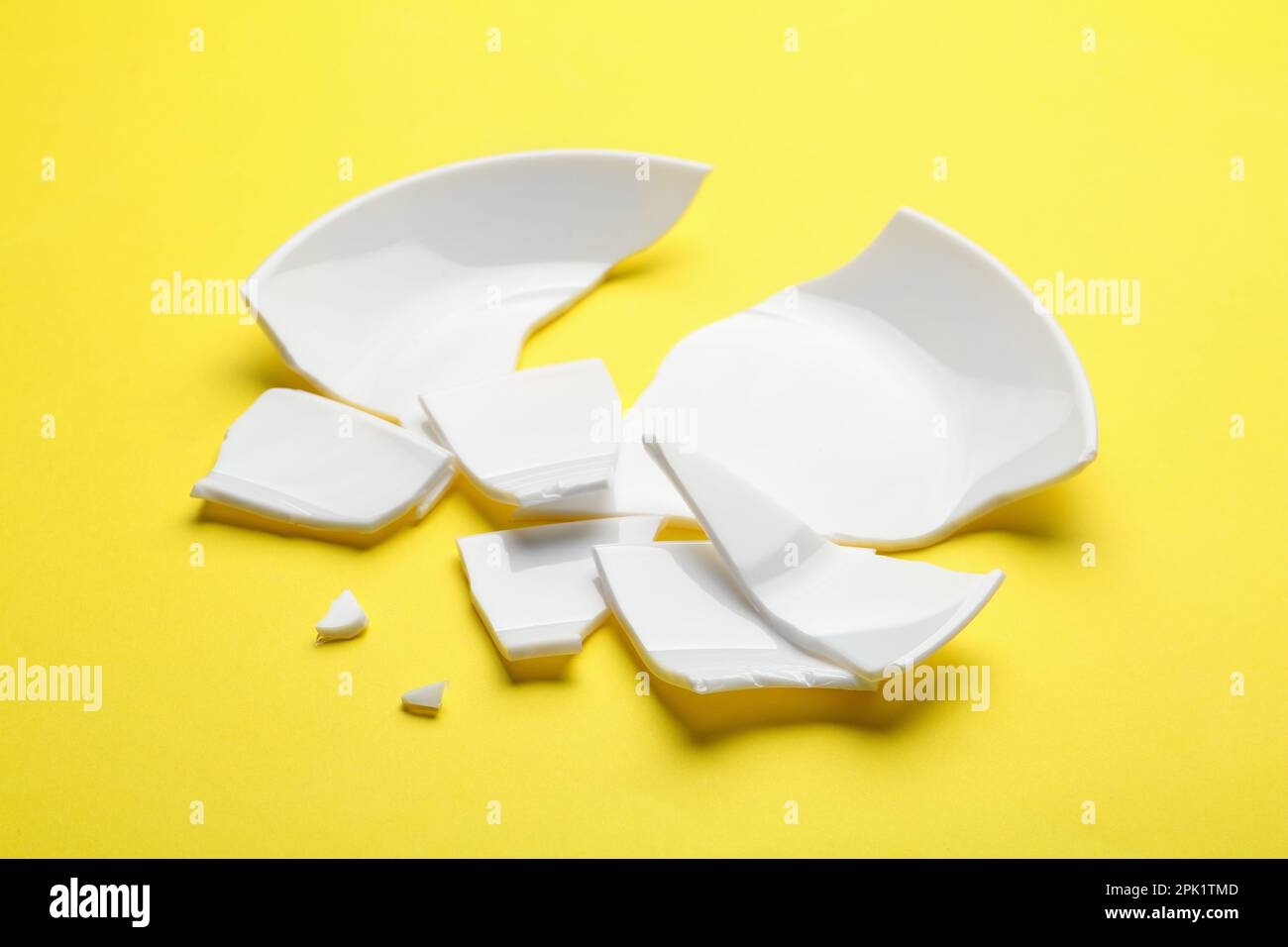 Pieces of broken ceramic plate on yellow background Stock Photo - Alamy