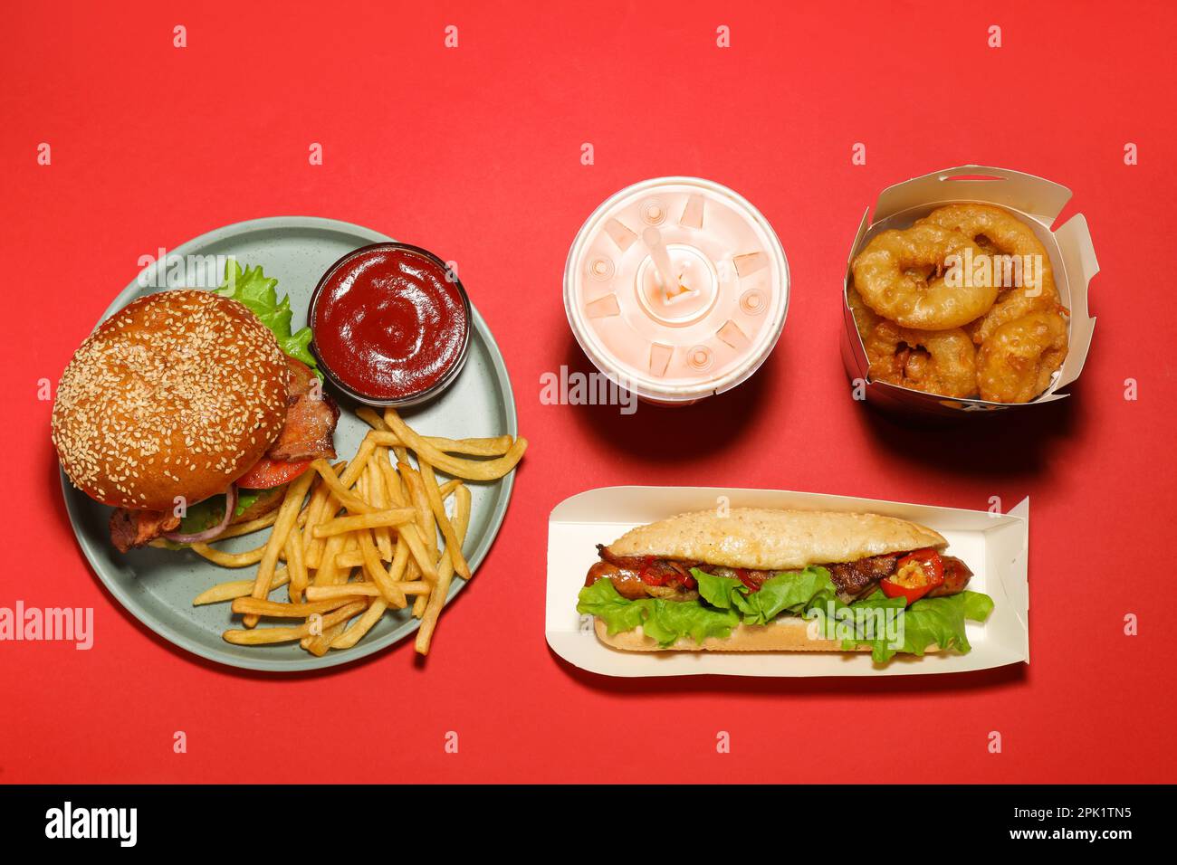 Tasty burger, French fries, hot dog, fried onion rings and refreshing ...