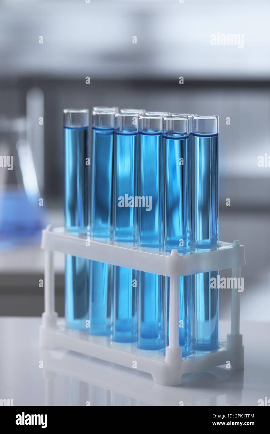 Test tubes with light blue liquid on table in laboratory Stock Photo ...