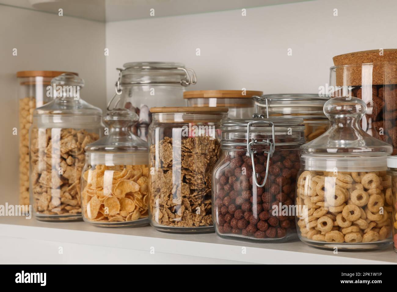Glass containers with different breakfast cereals on shelf Stock Photo ...