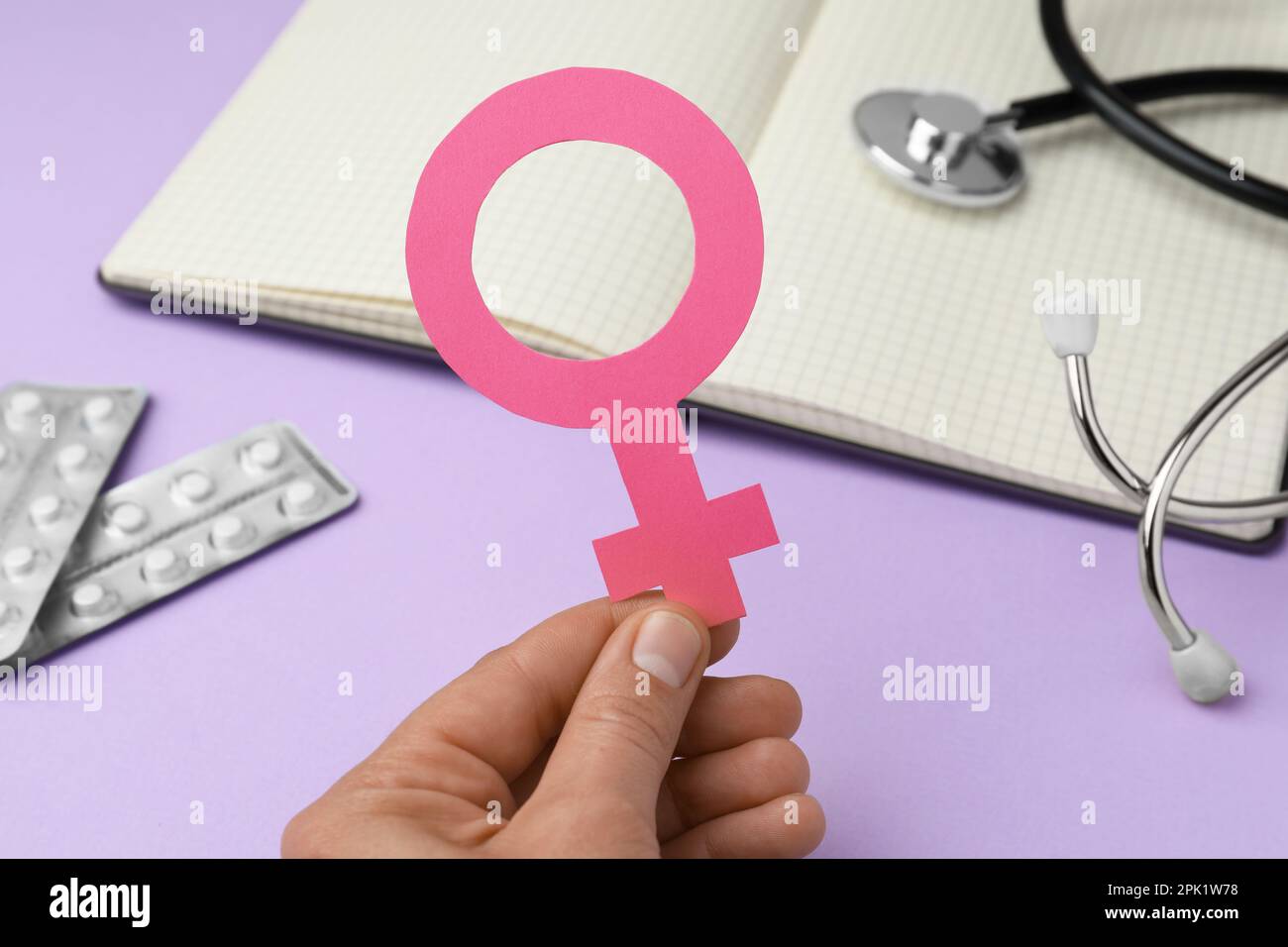 Girl holding female gender sign near open notebook, stethoscope and ...