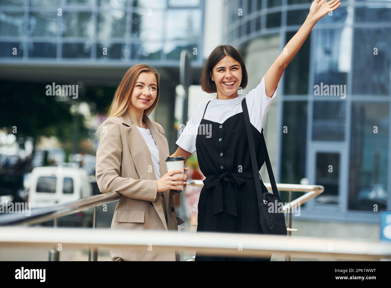 Good friends. Women in formal wear is outdoors in the city together ...