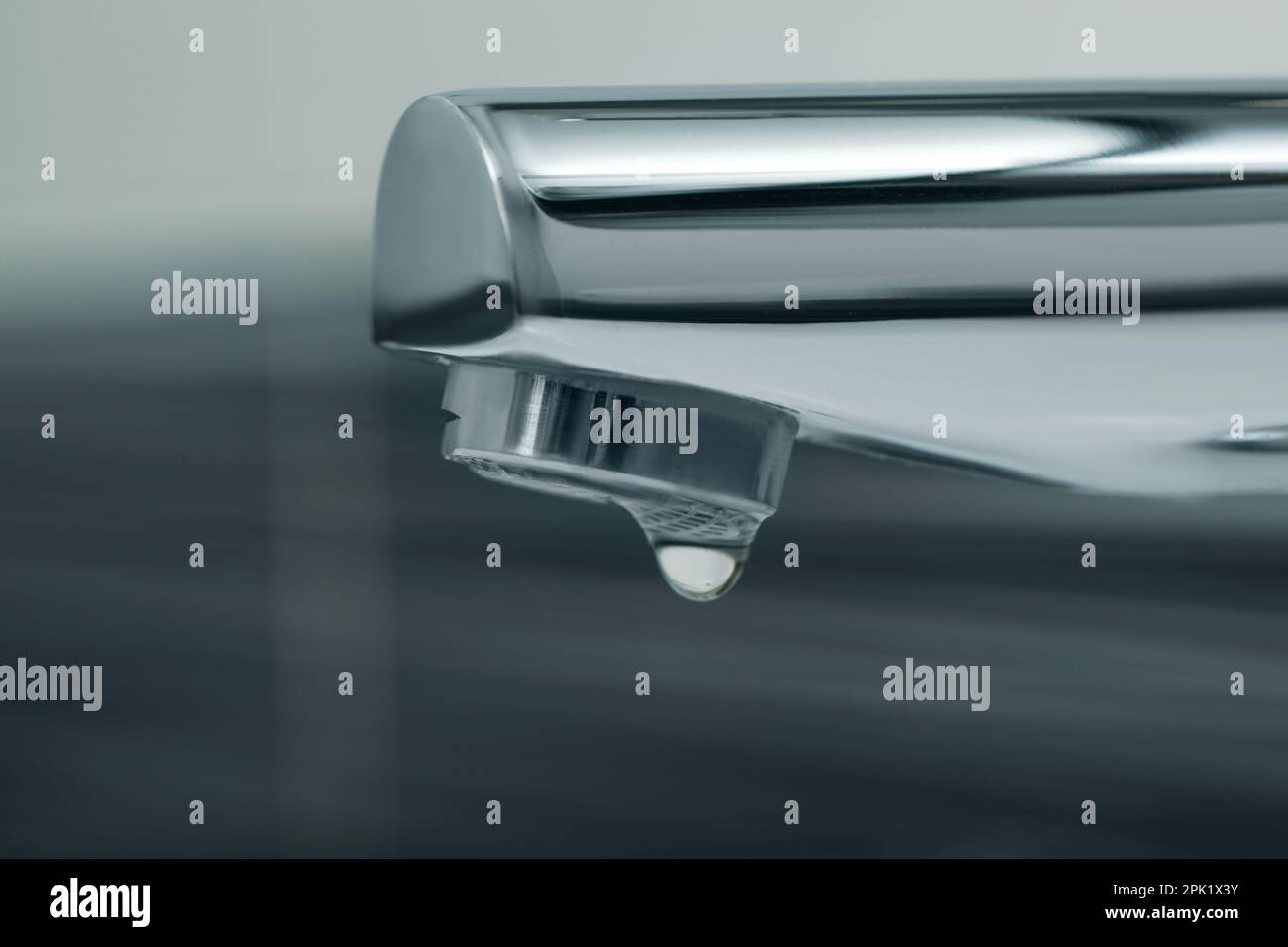 Water drop falling down from tap on blurred background, closeup Stock ...