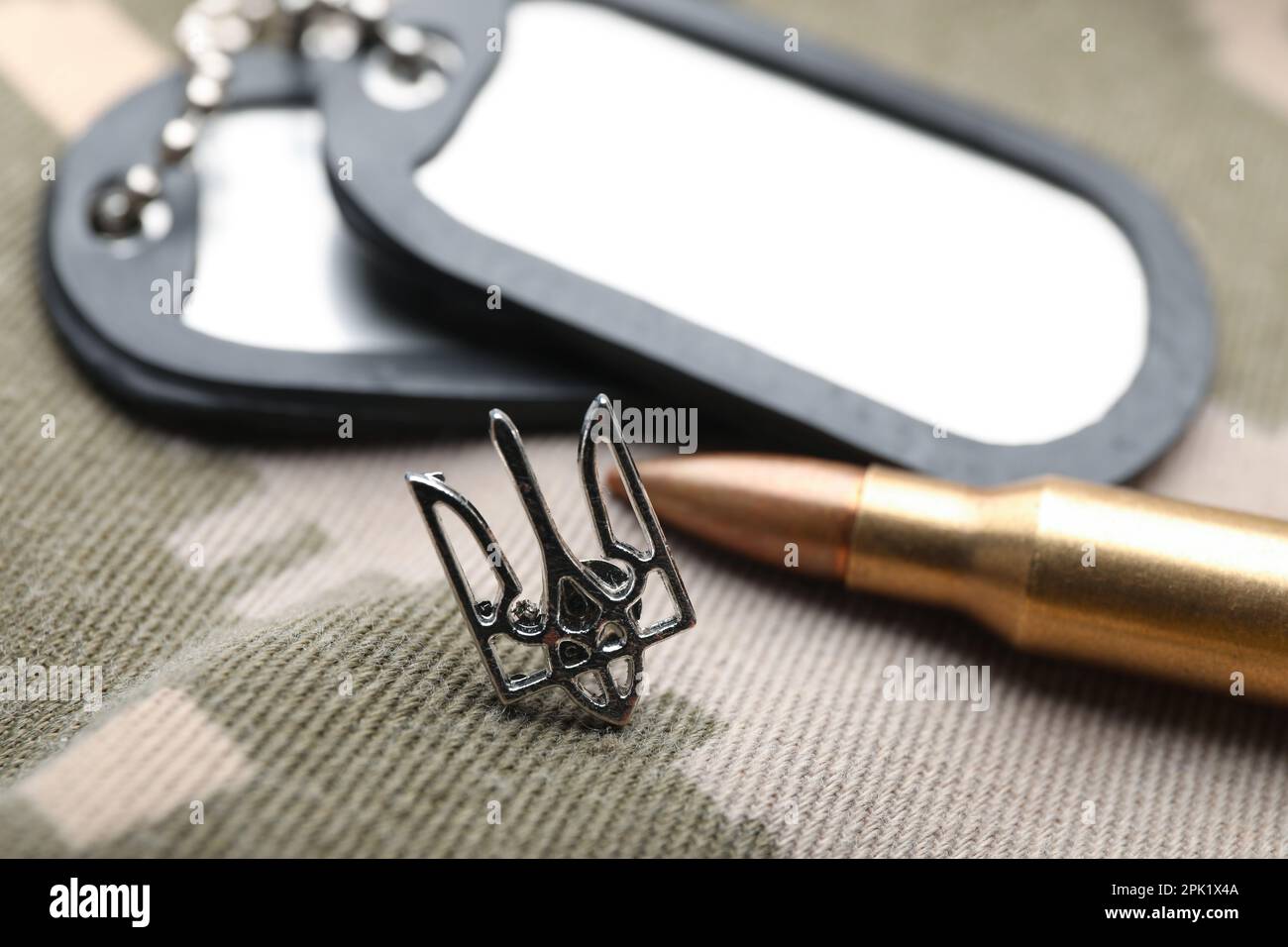 Ukrainian trident near military ID tags and bullet on camouflage ...