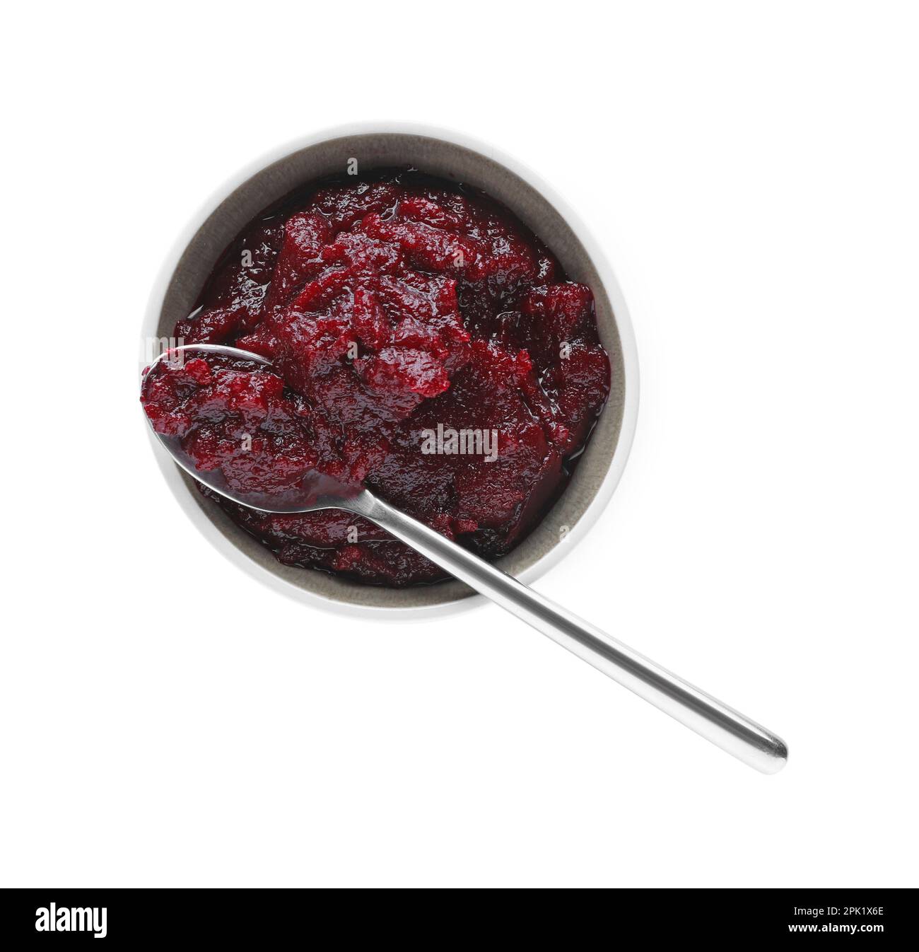 Delicious beetroot puree and spoon in bowl isolated on white, top view ...