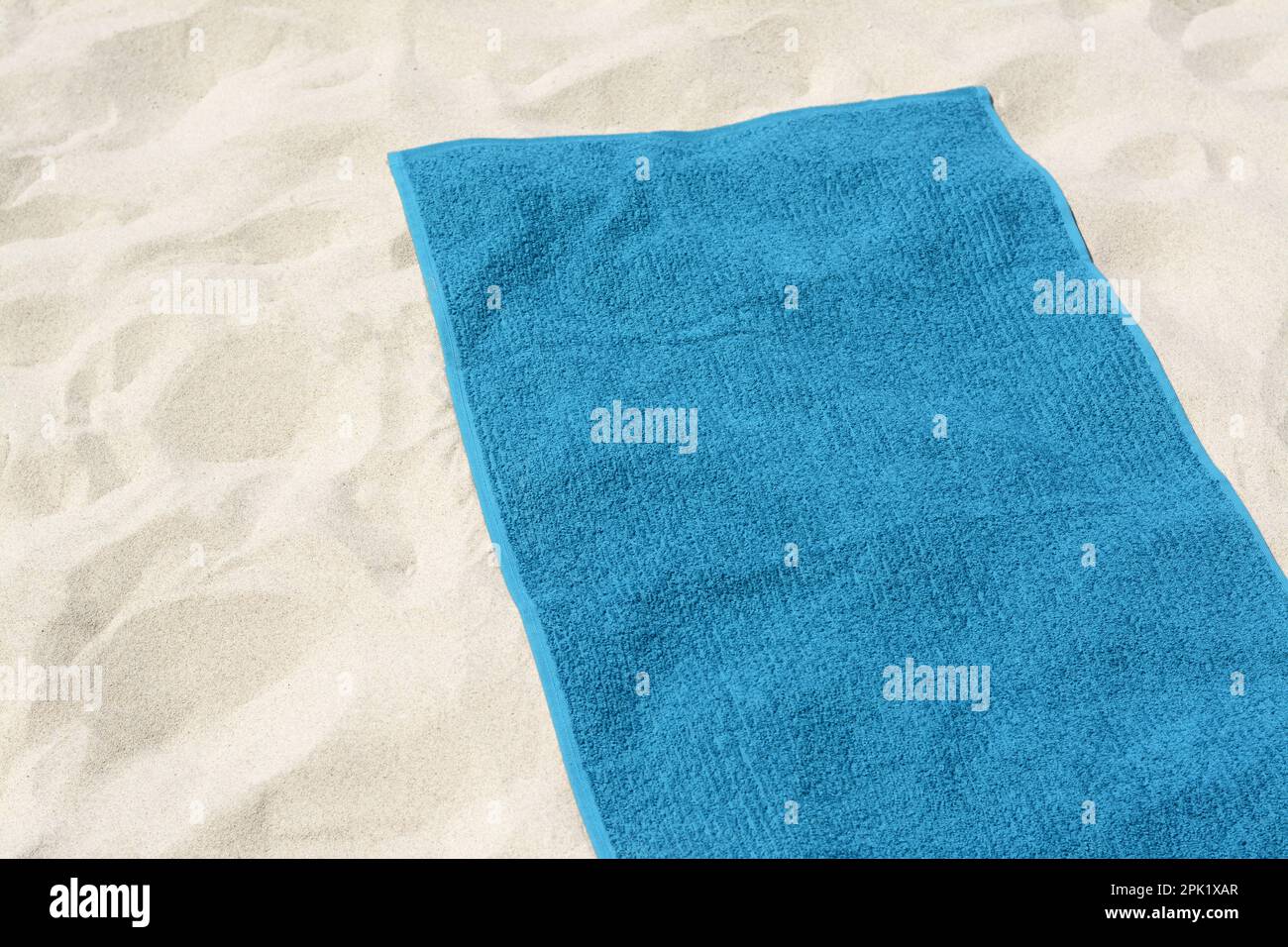 Beautiful soft blue towel on sandy beach Stock Photo - Alamy