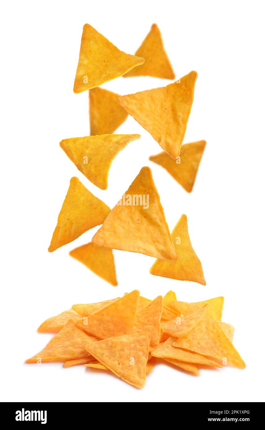 Tasty tortilla chips (nachos) falling into pile on white background ...