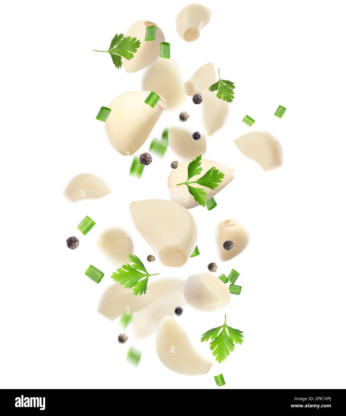 Fresh peeled garlic cloves, peppercorns and parsley flying on white ...