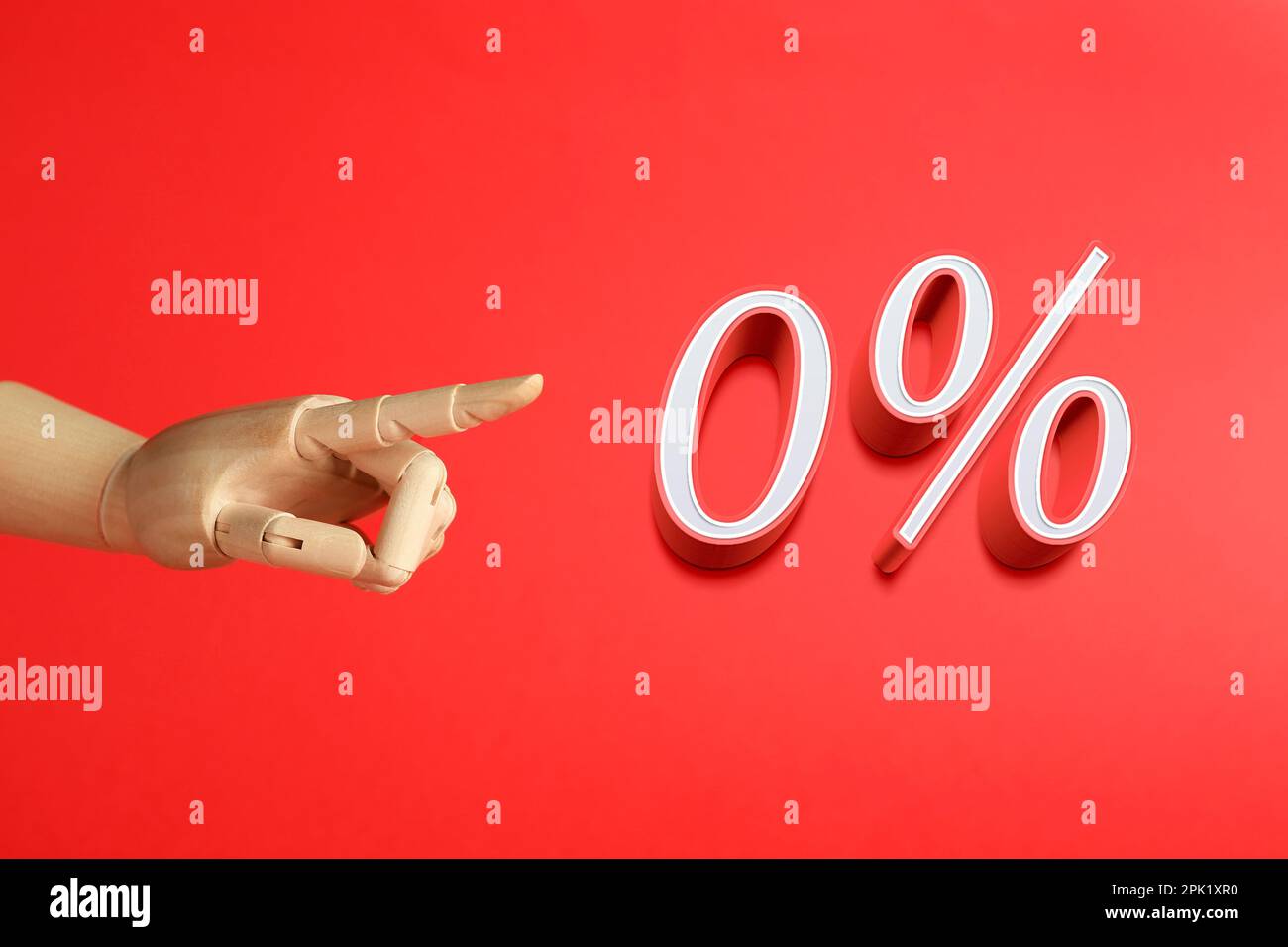 Wooden mannequin hand pointing at sign of zero percent on red ...