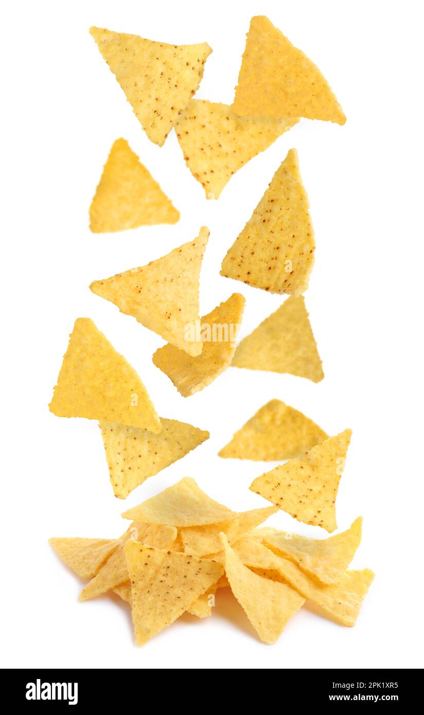 Tasty tortilla chips (nachos) falling into pile on white background ...