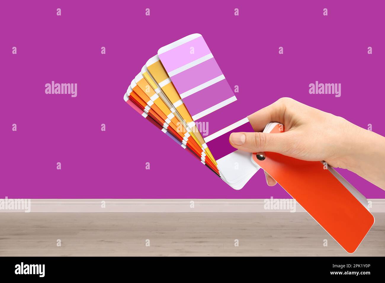 Decorator holding color palette samples in room with painted wall ...