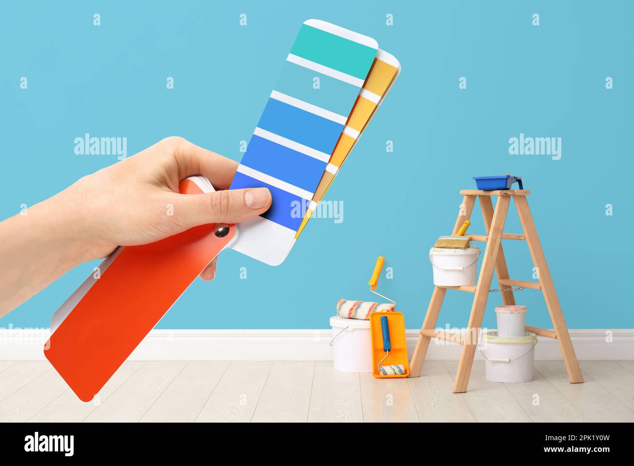 Decorator holding color palette samples in room with painted wall ...