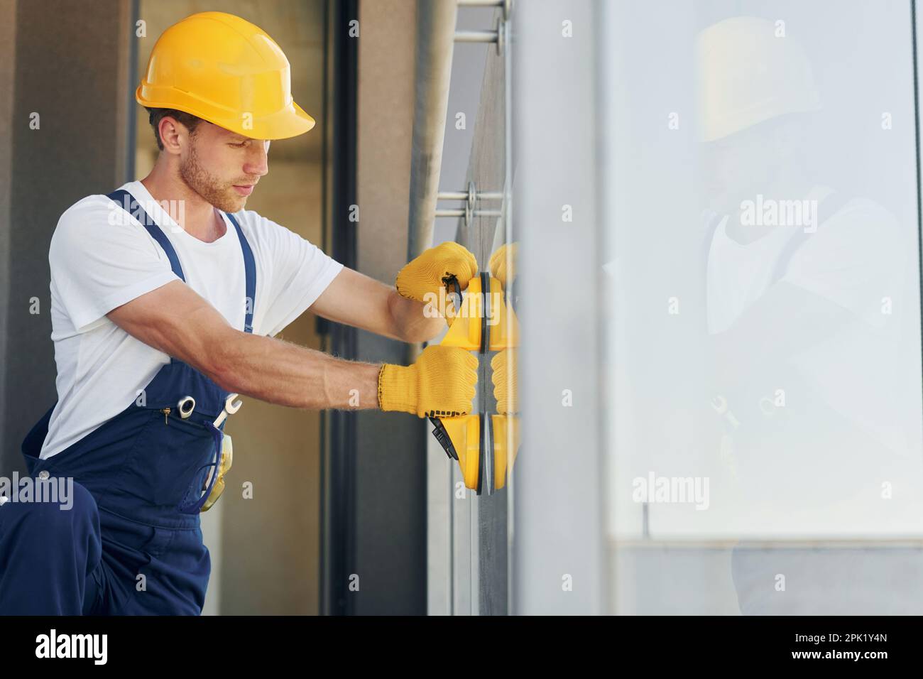 Side view. Young man working in uniform at construction at daytime ...