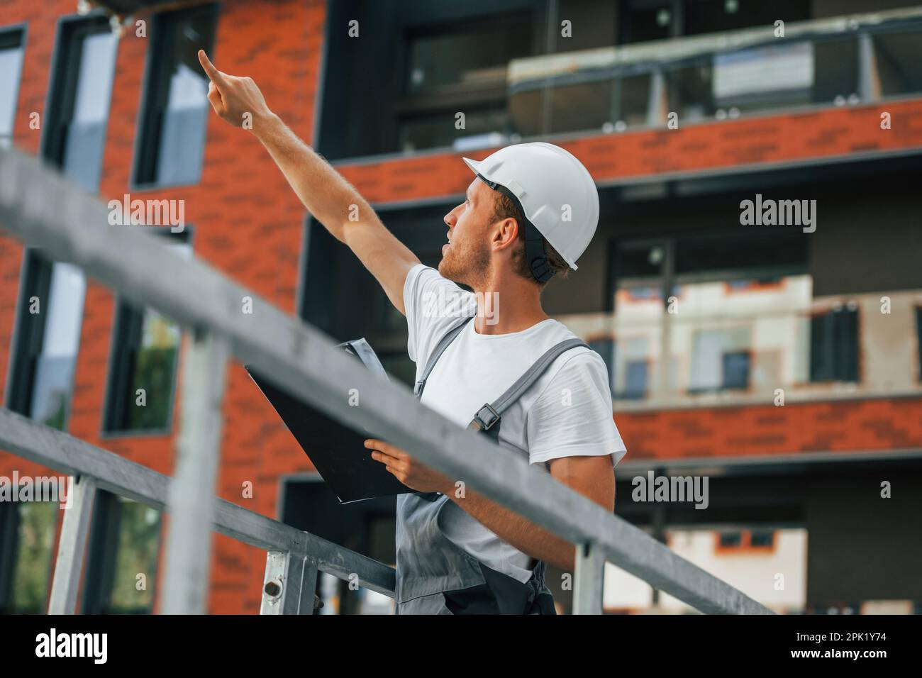 Unfinished project. Young man working in uniform at construction at ...