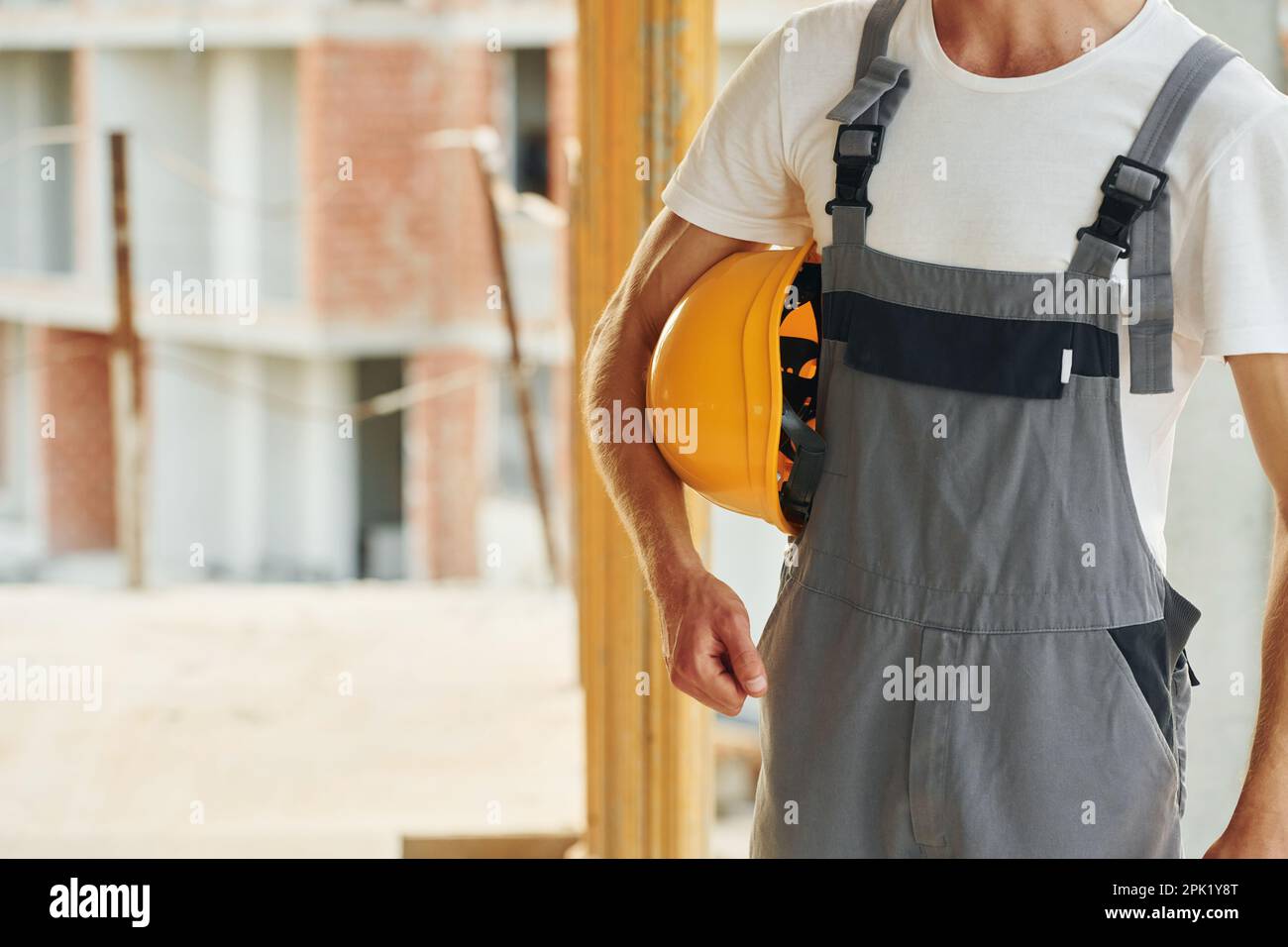 Unfinished project. Young man working in uniform at construction at ...