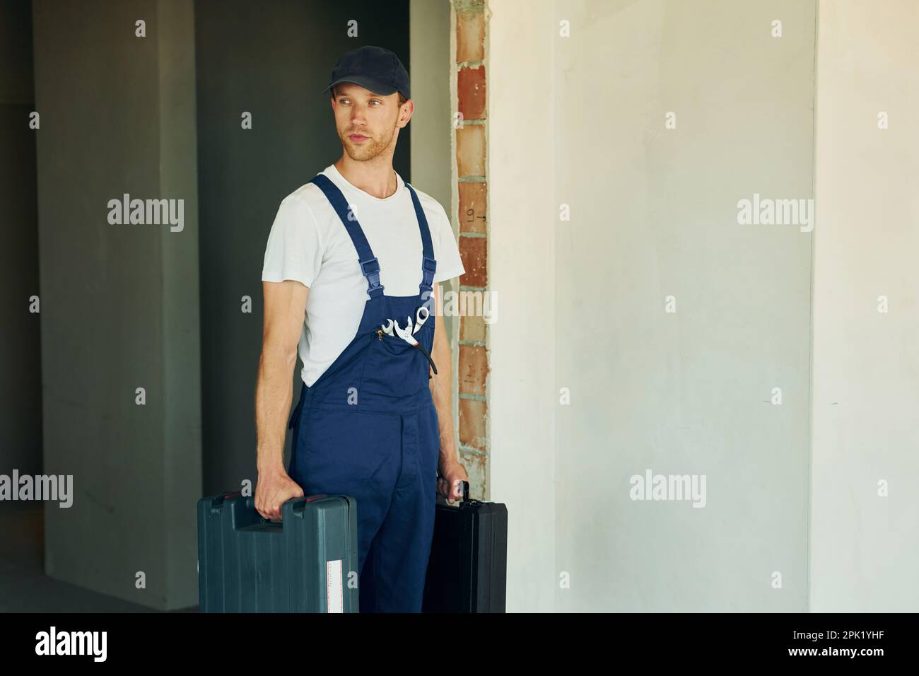 Opening the case. Young man working in uniform at construction at ...