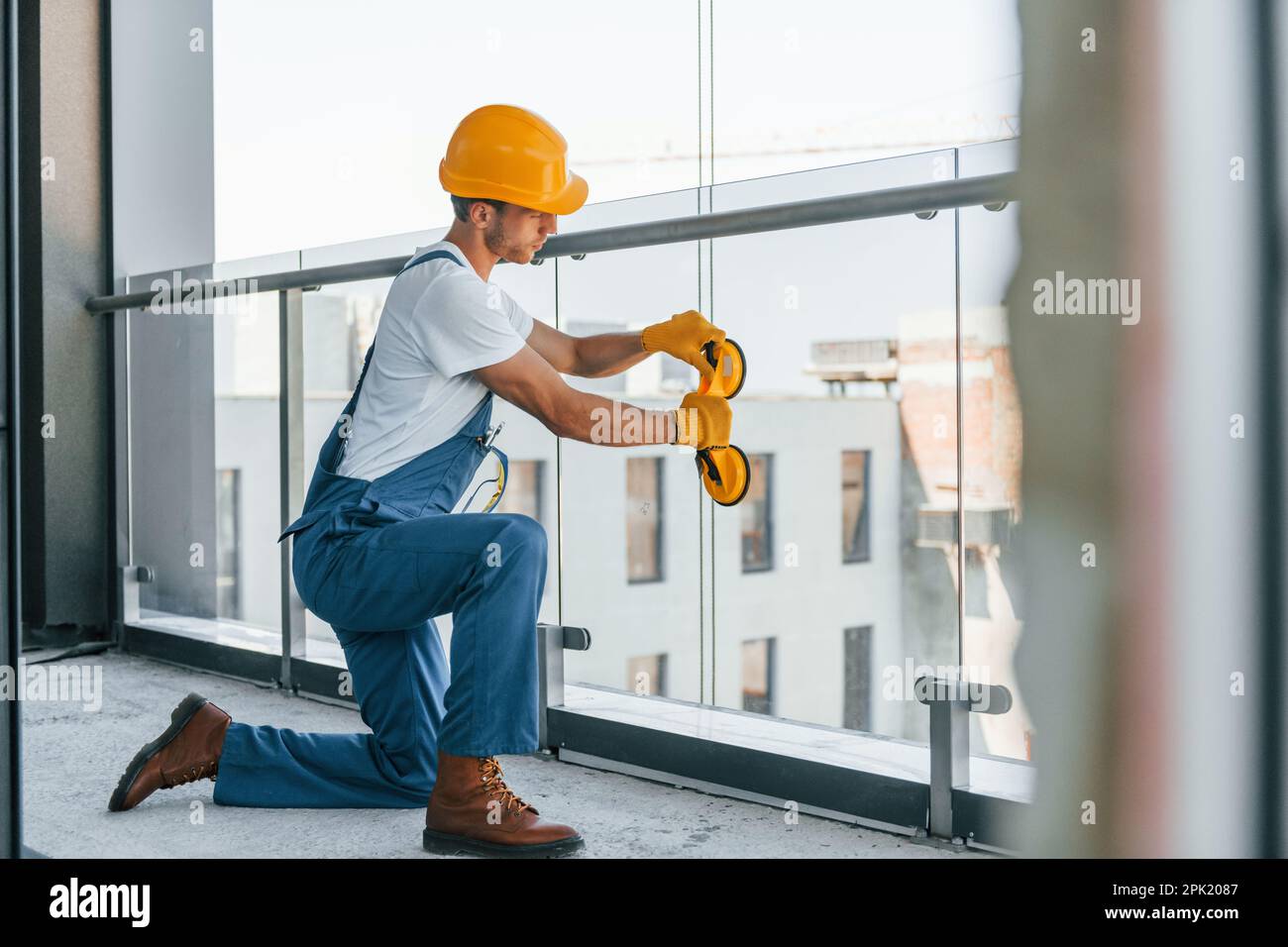 Installation of windows. Young man working in uniform at construction ...