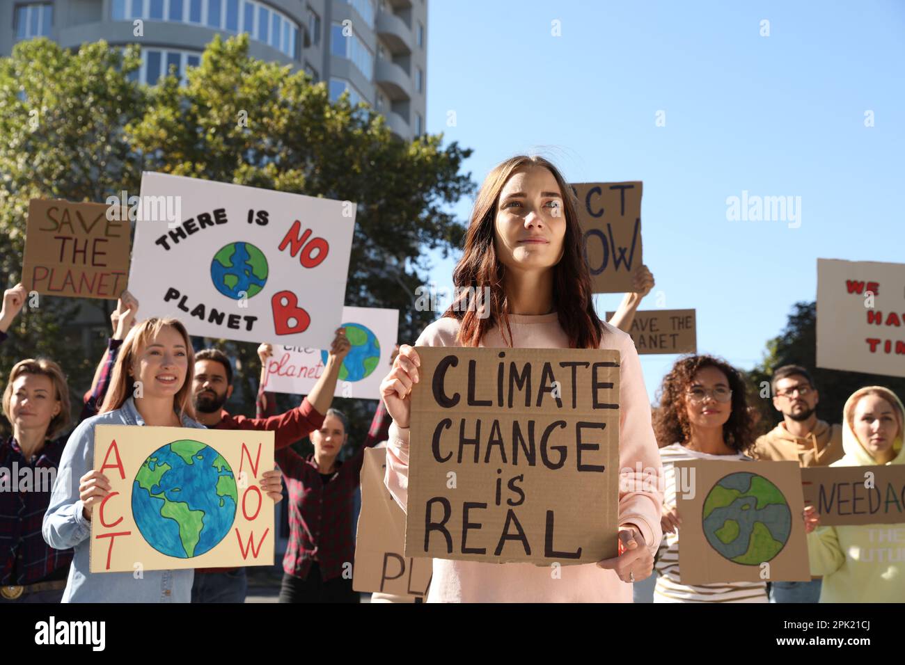 Group of people with posters protesting against climate change outdoors ...