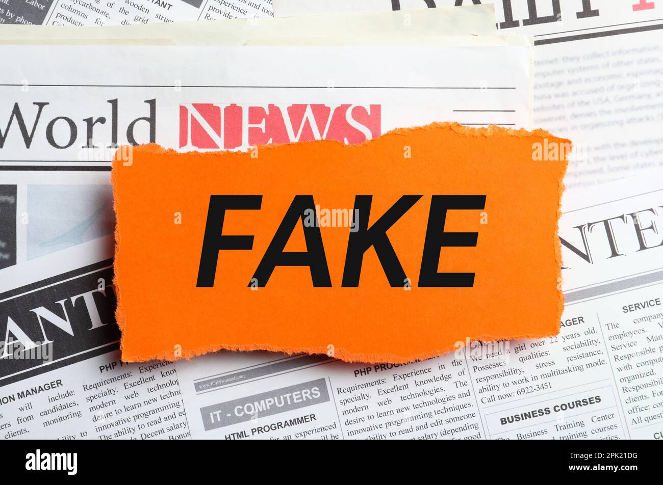 Orange paper piece with word FAKE on pile of newspapers, top view Stock ...