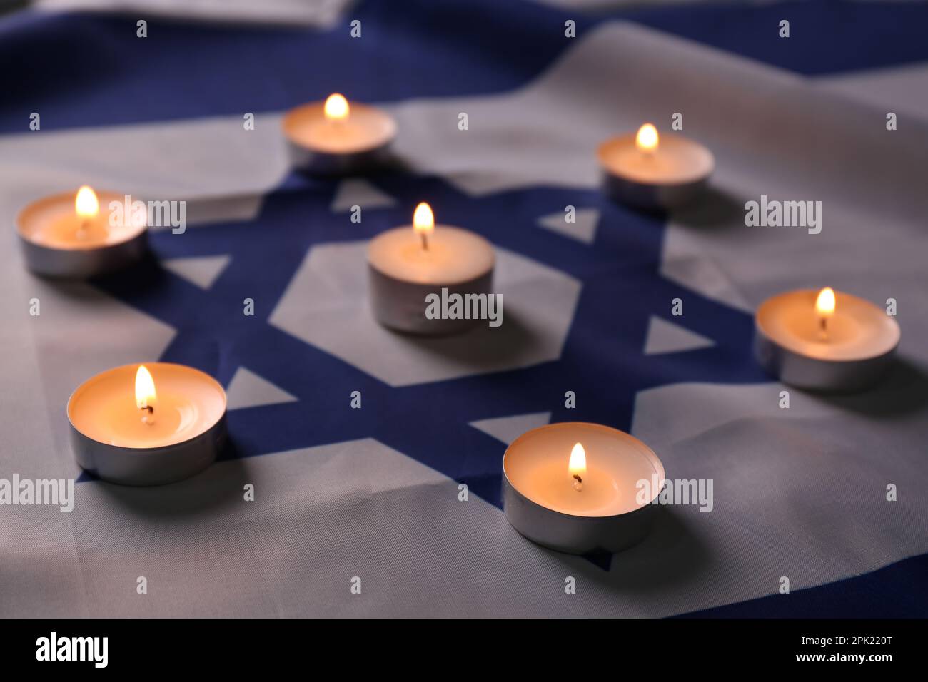 Burning candles on flag of Israel. Holocaust memory day Stock Photo - Alamy