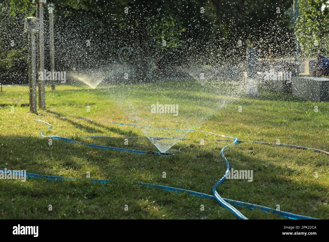 Automatic sprinkler watering green grass in park. Irrigation system ...