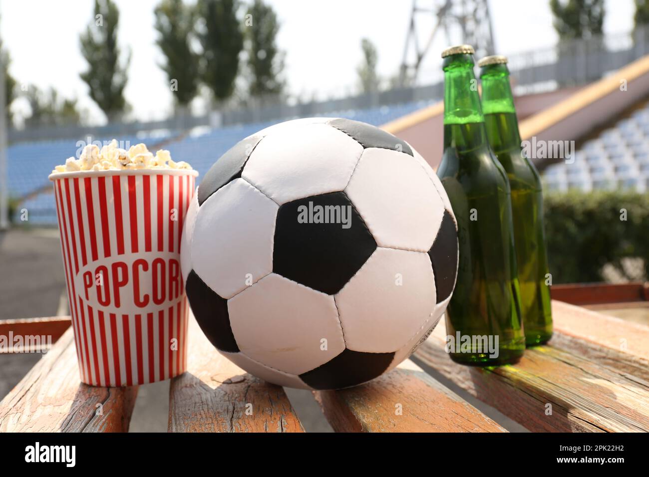 Football ball with beer and popcorn on wooden bench in stadium Stock ...