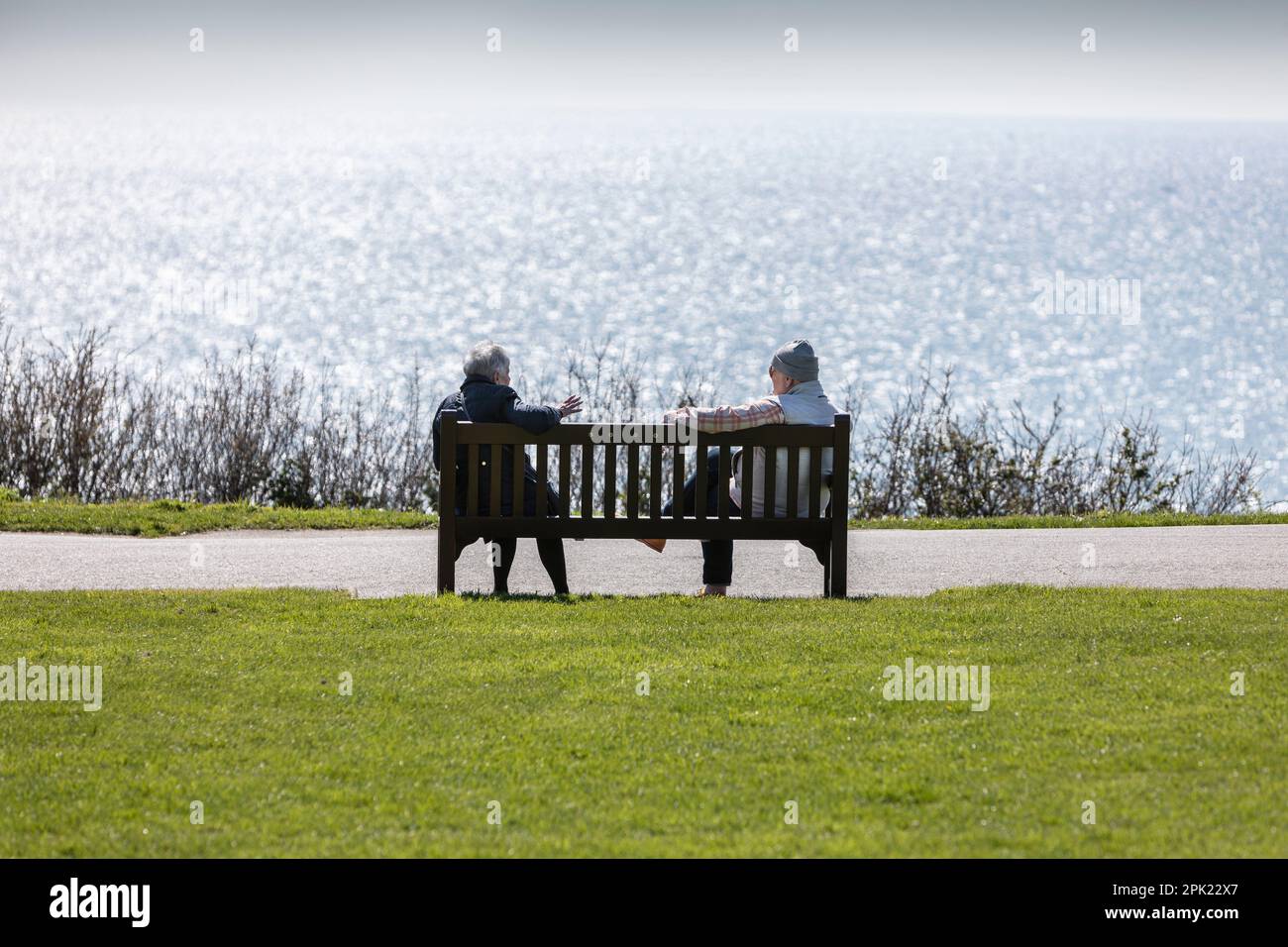 Two men chatting on a bench overlooking the English Channel in ...