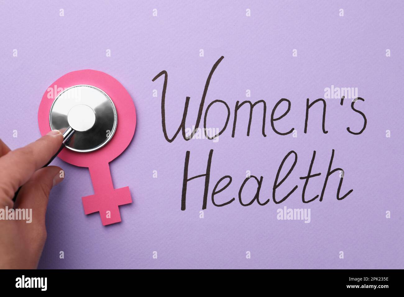 Doctor holding stethoscope near female gender sign and text Women's ...