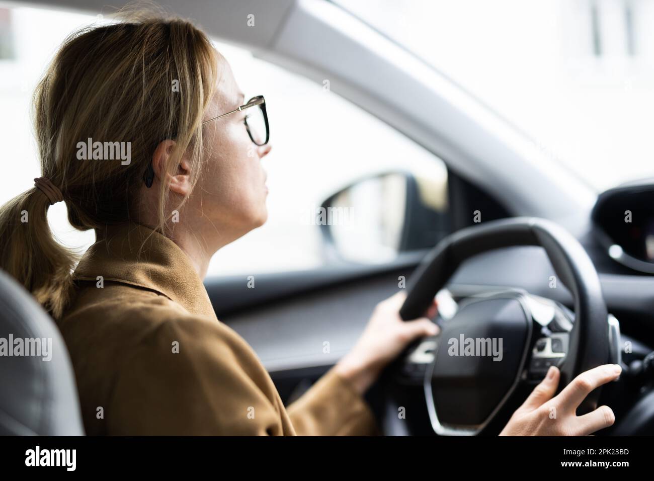 Business woman driving a car to work. Female driver steering car on the ...