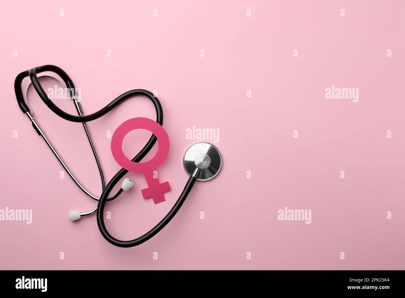 Female gender sign and stethoscope on pink background, flat lay. Space ...