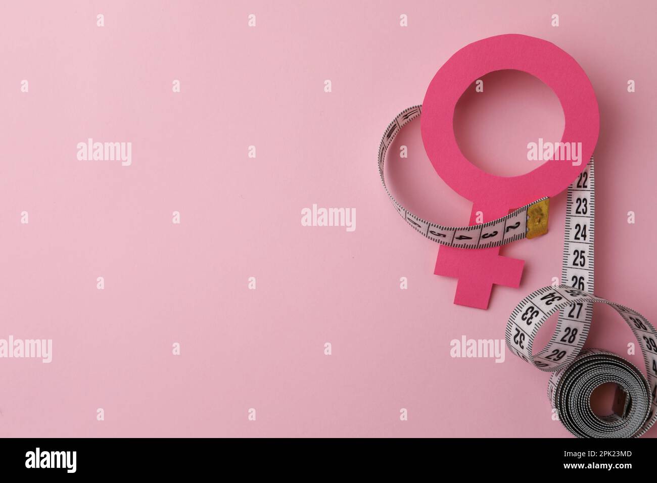 Female gender sign and measuring tape on pink background, flat lay ...