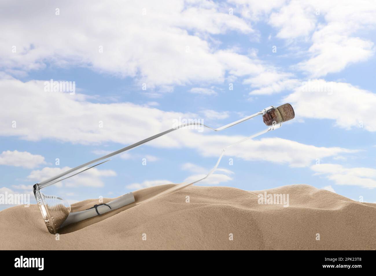 Corked glass bottle with rolled paper note on sand against sky Stock ...