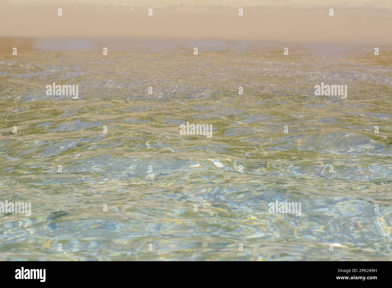 Beautiful sea water with ripples and sandy shore Stock Photo - Alamy