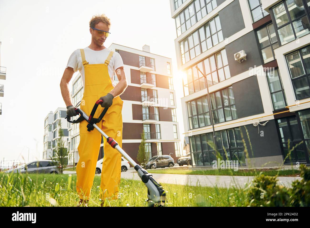 One person. Man cut the grass with lawn mover outdoors in the yard ...