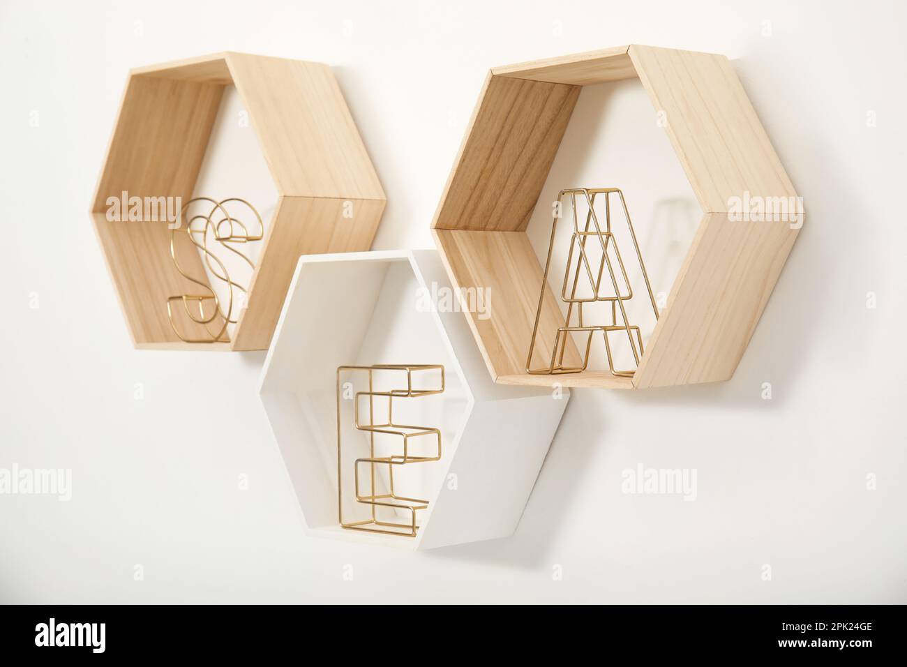Honeycomb shaped shelves with decorative elements on white wall Stock ...