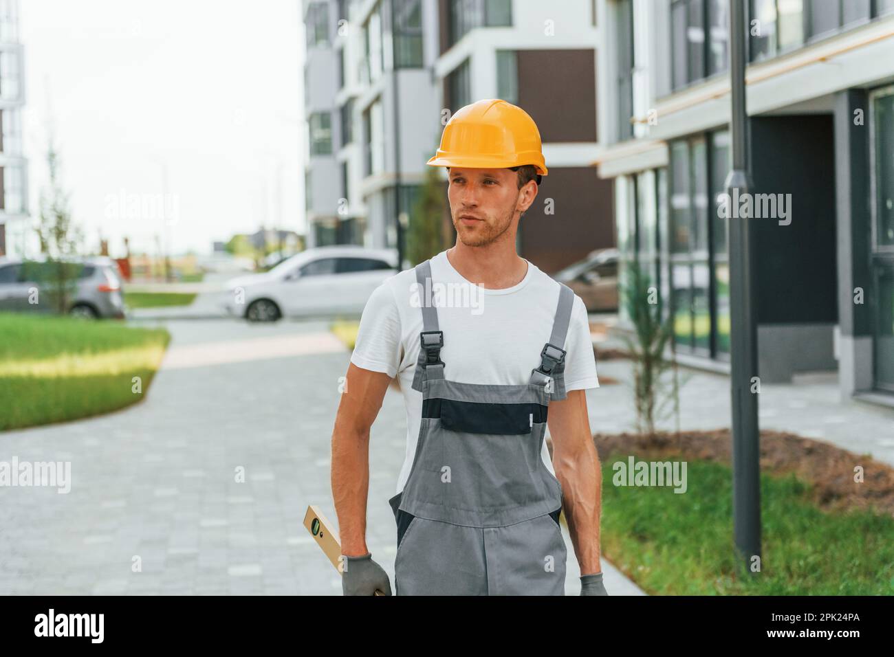 Walking outdoors. Young man working in uniform at construction at ...