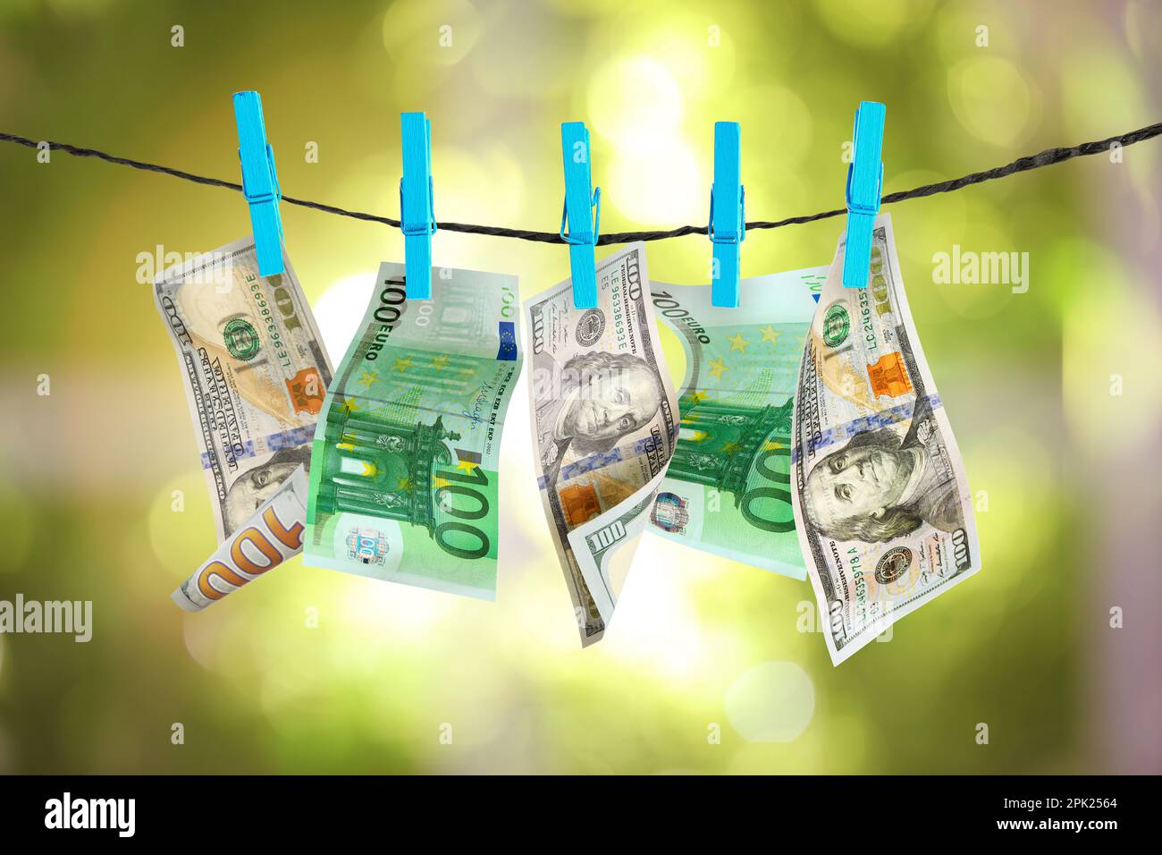 Money laundering. Banknotes hanging on clothesline outdoors Stock Photo ...