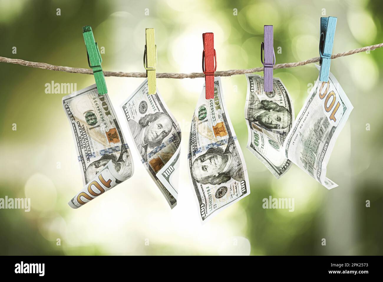 Money laundering. Dollar banknotes hanging on clothesline outdoors ...