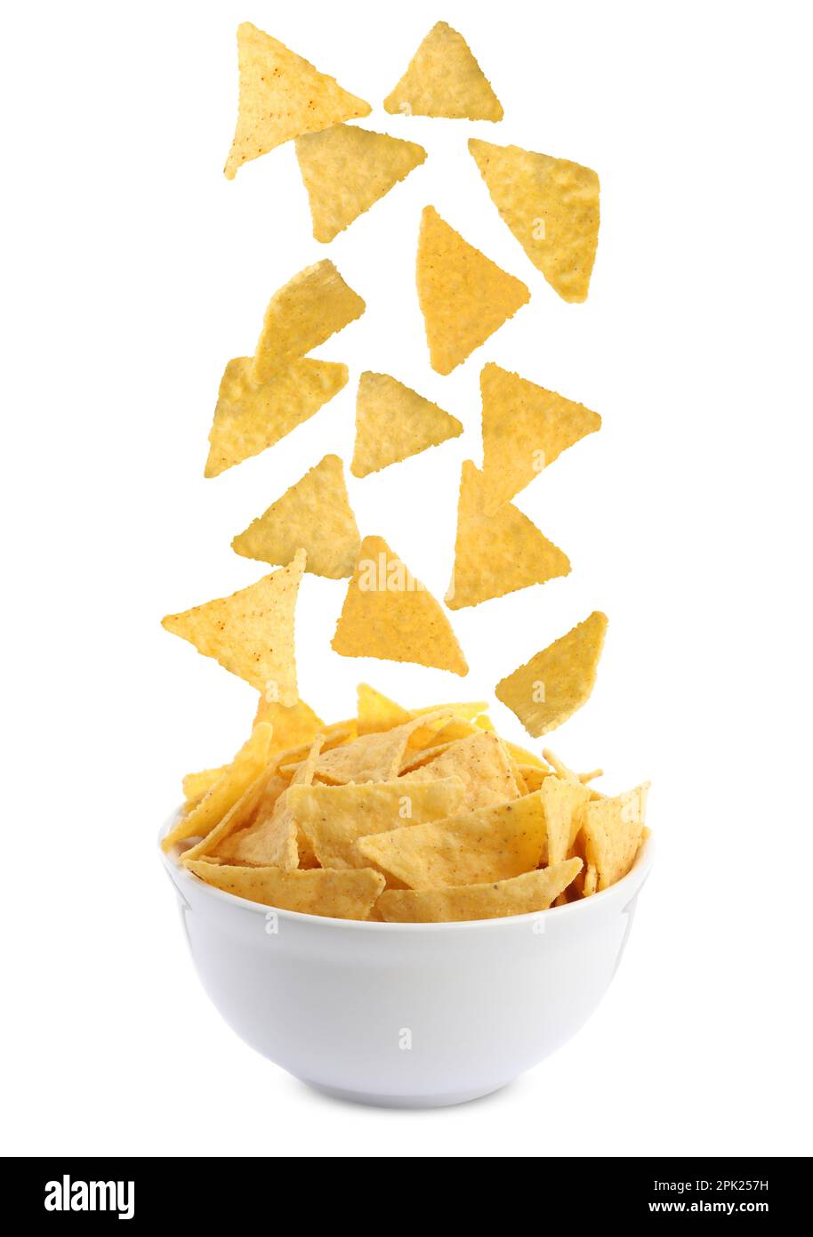 Tasty tortilla chips (nachos) falling into bowl on white background ...