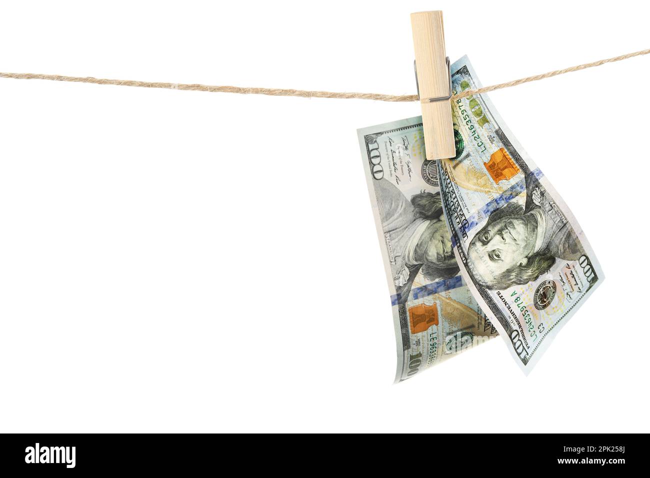 Money laundering. Dollar banknotes hanging on clothesline against white ...
